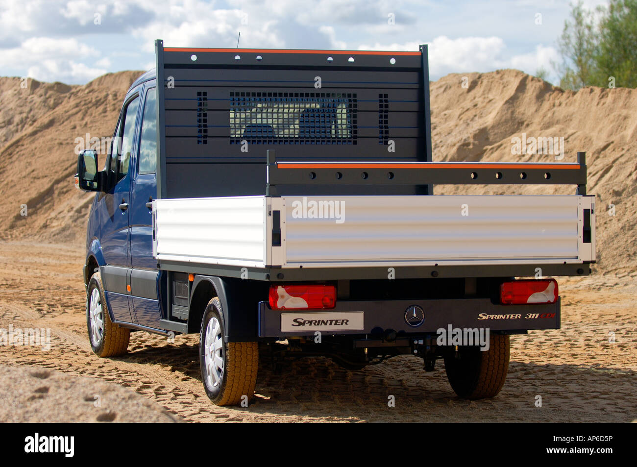 Rear view of blue mercedes benz sprinter side loader van in sand quarry ...