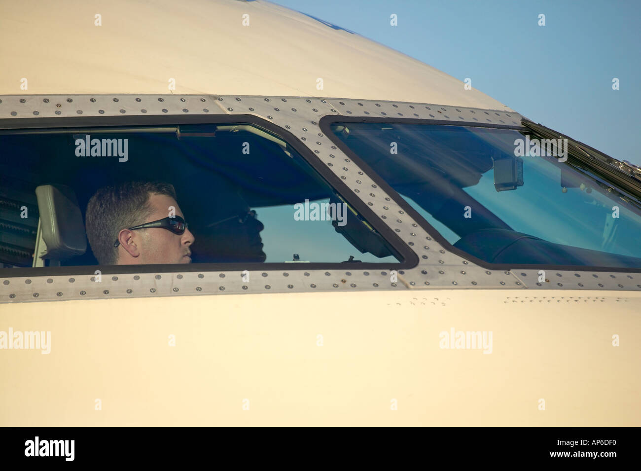 Side view of passenger jet airplane cockpit windsheild with pilots ...