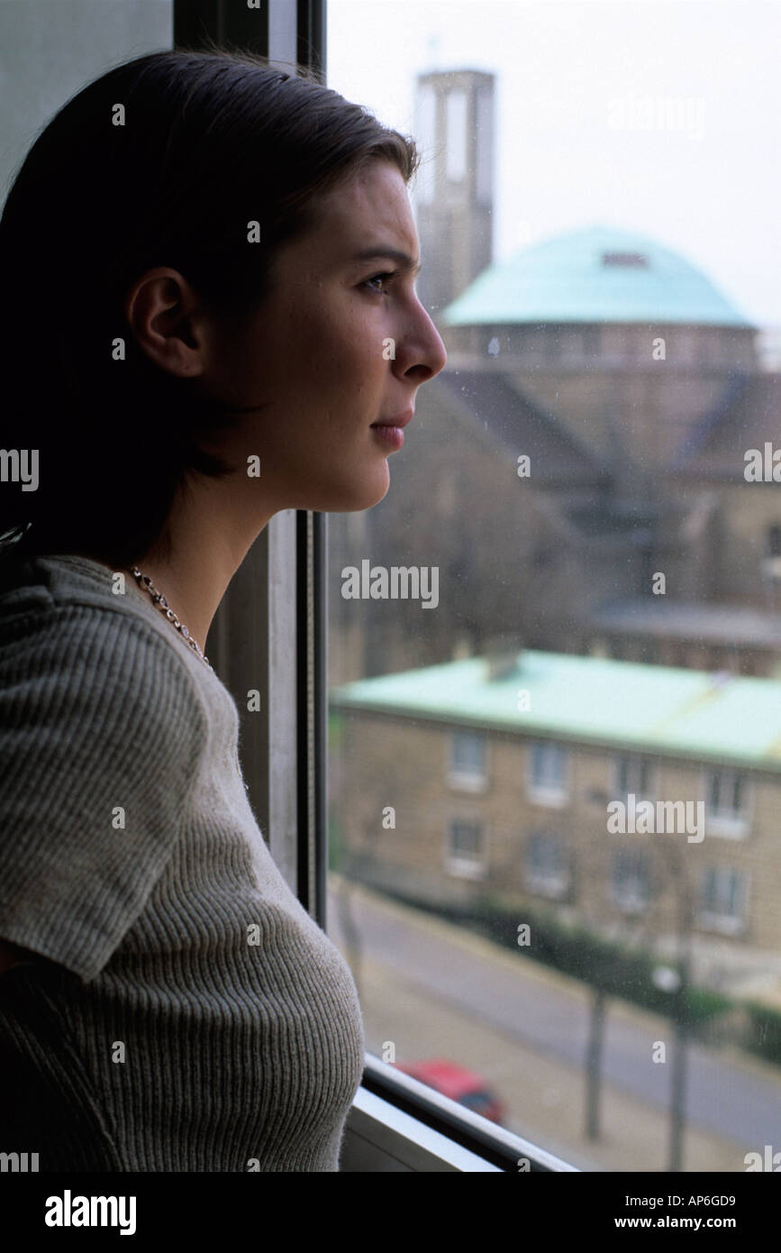 A french woman looking pensive out the window in Paris France Stock ...