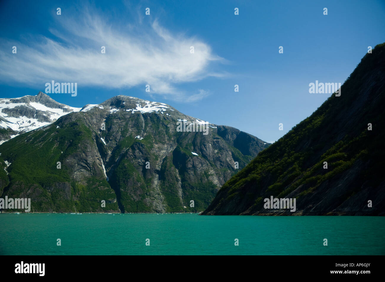 Mountains rise dramatically from waters colored aqua from glacial silt ...