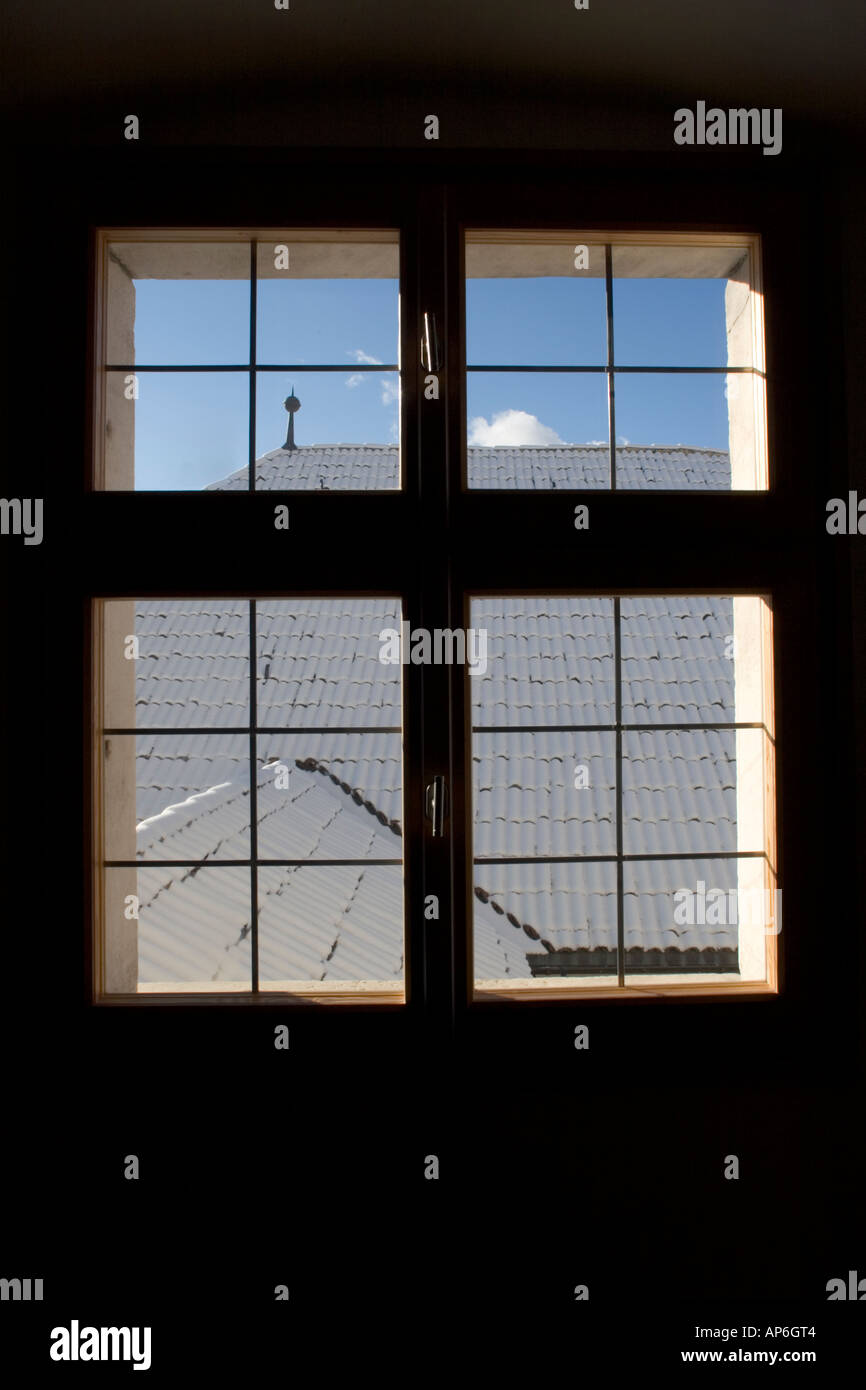 Window from inside looking at over snowy roof and blue sky Stock Photo ...