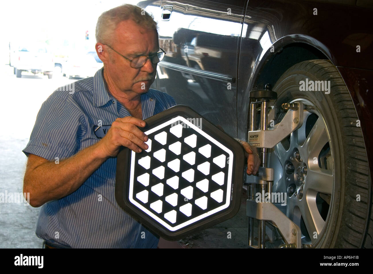 Technician performing wheel alignment on automobile Stock Photo - Alamy