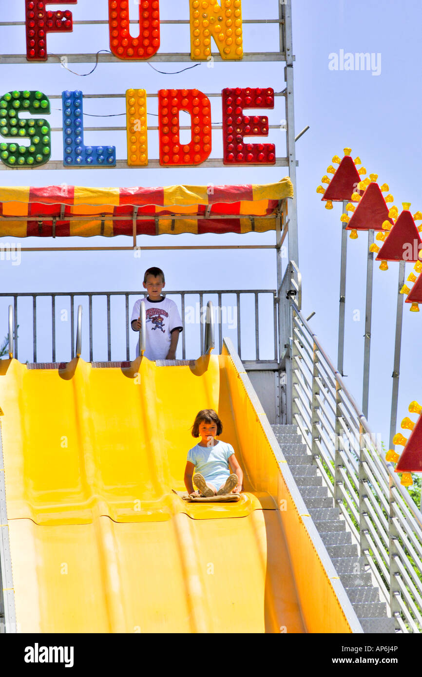 Children having fun on the slide at the travelling fairground in ...