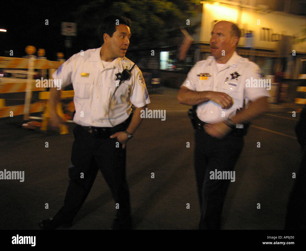 Two Chicago police officers walking quickly in Lincoln Square area ...