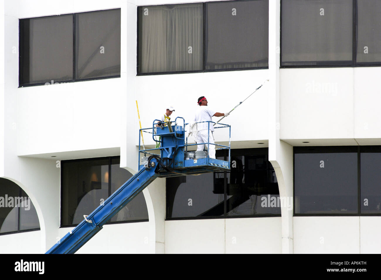 Painters using a hydrolic lift whilst painting a building Stock Photo ...