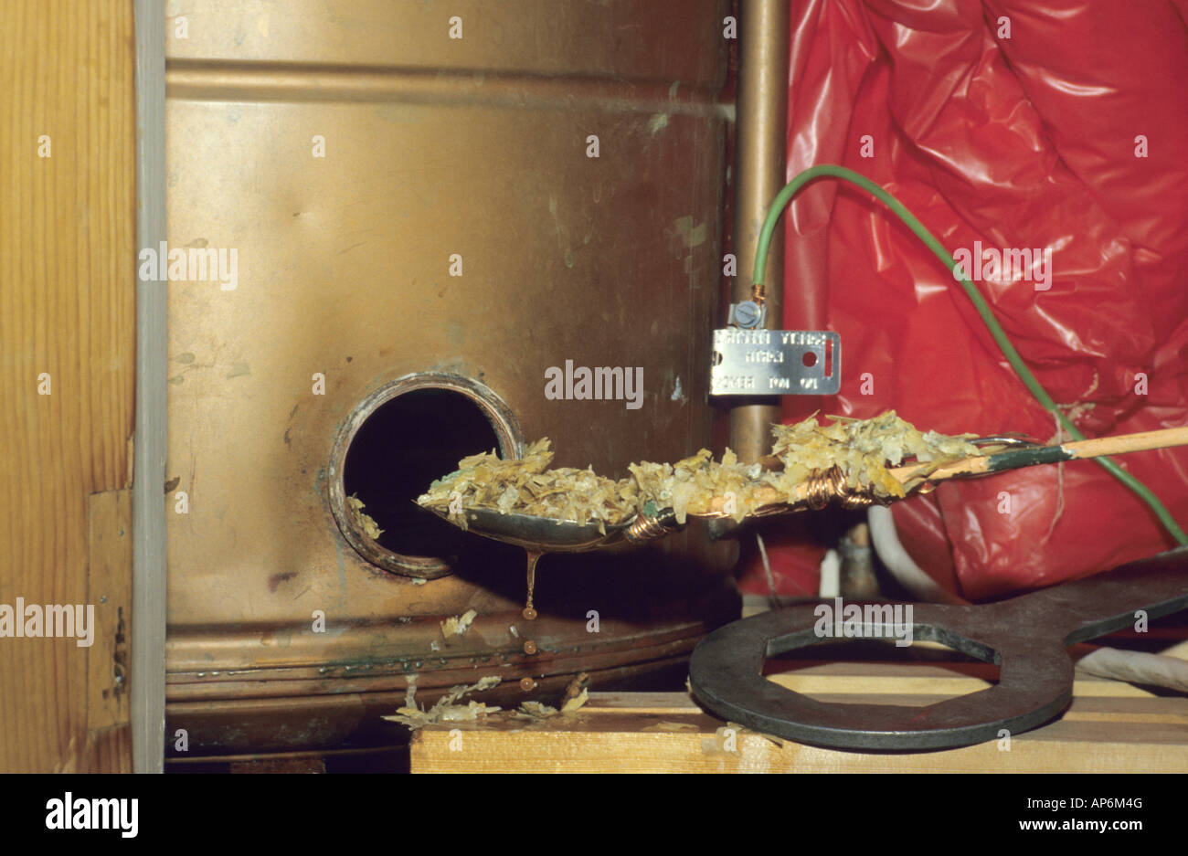 Plumber clearing calcium from hot water cistern Stock Photo - Alamy
