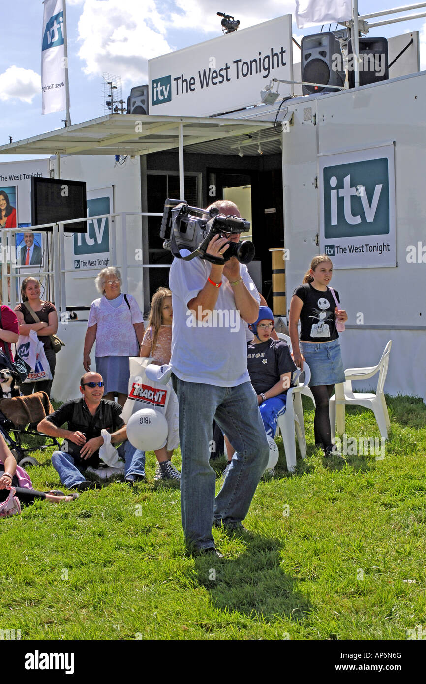 TV media cameraman at an outside broadcast summer event walking around ...