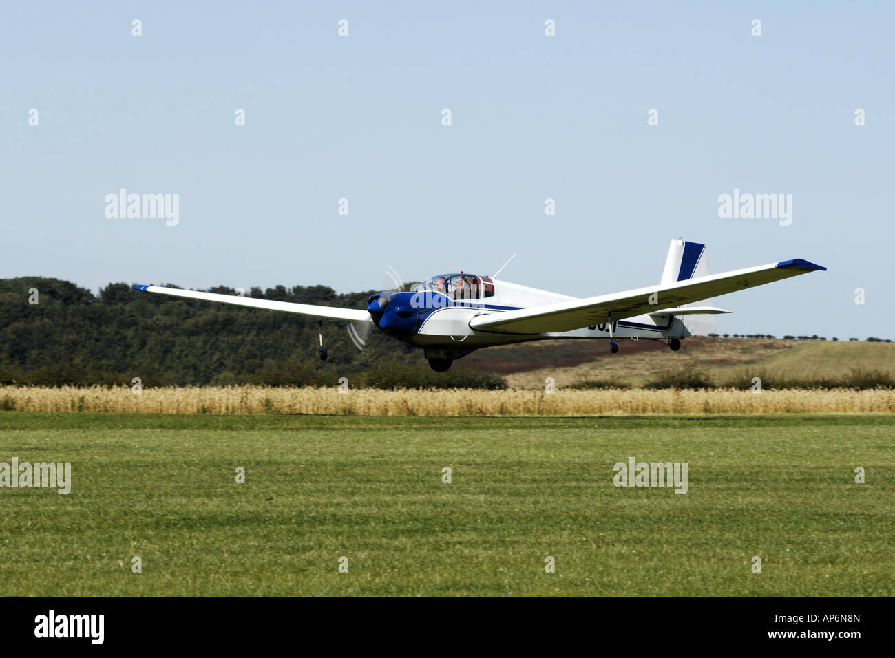 A powered Glider takes off from a grass runway at a small airfield in ...