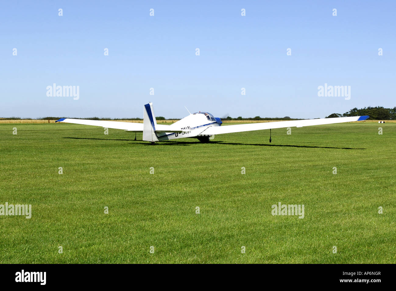A powered Glider takes off from a grass runway at a small airfield in ...