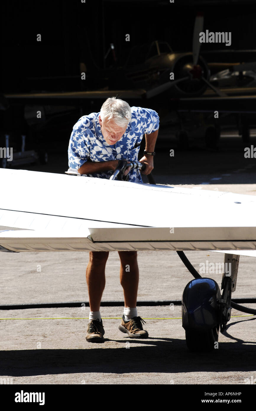 Adult male filling the wing tanks on his aircraft with fuel before a ...
