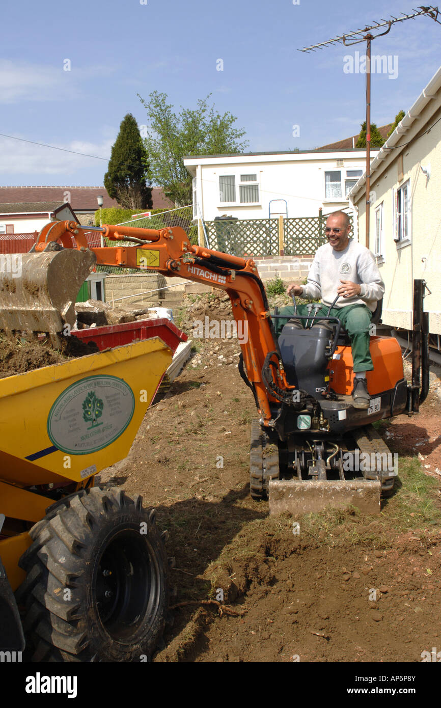 A mini digger excavating soil from a garden Stock Photo - Alamy