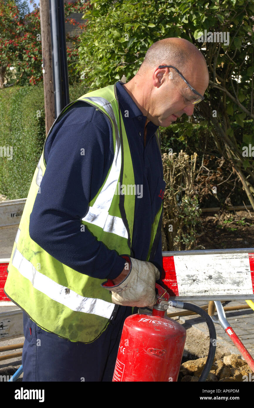 Adult male worker with a fire extinguisher ready to put out any fire as ...