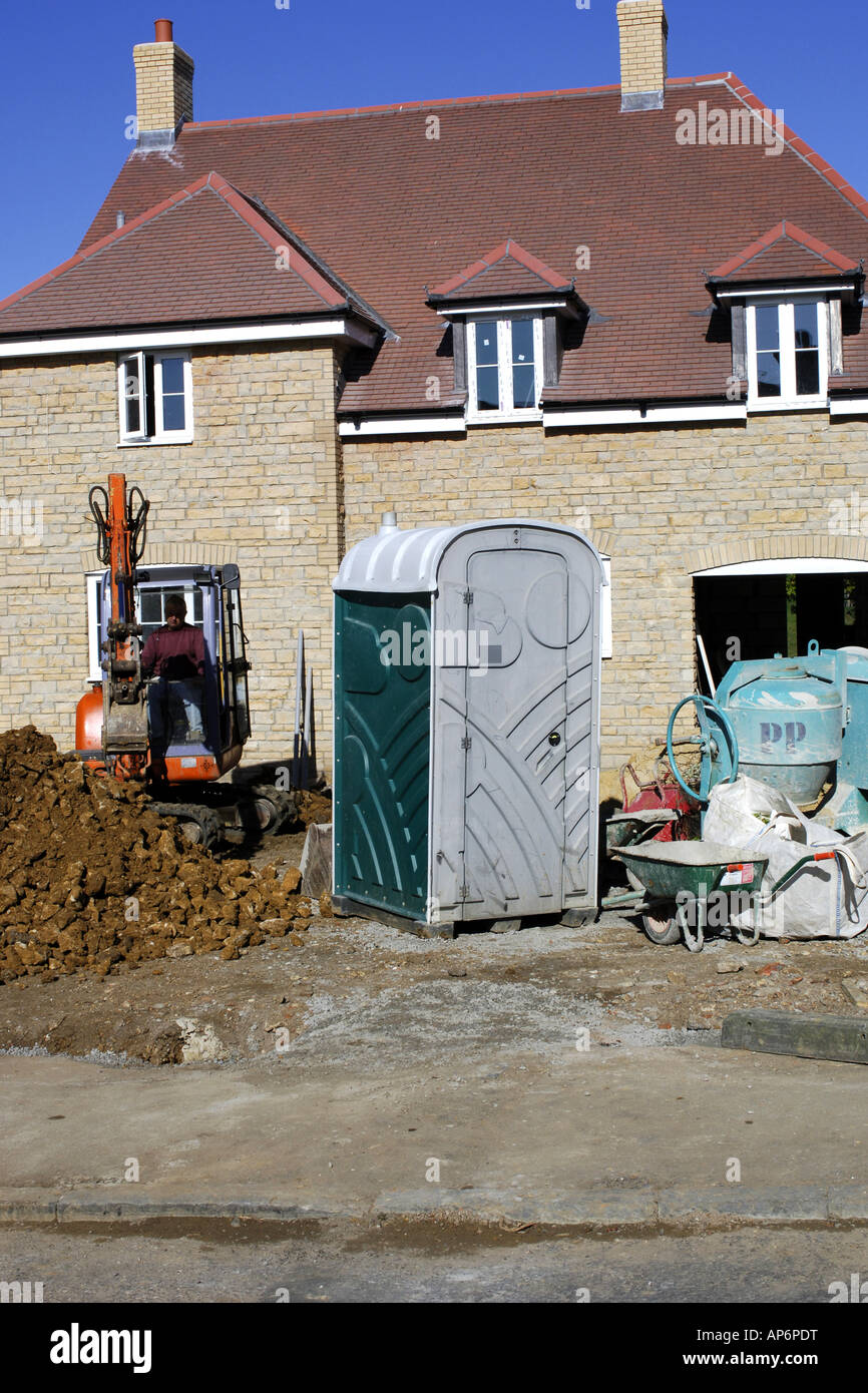 A mini digger being operated at a housing project to dig trenches for ...
