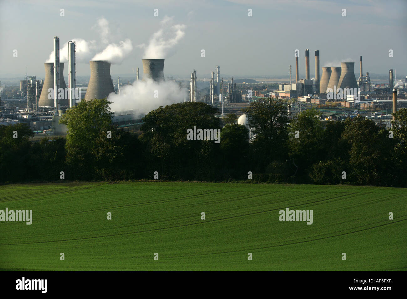 steam coming out of cooling towers of an oil refinery with fields in ...