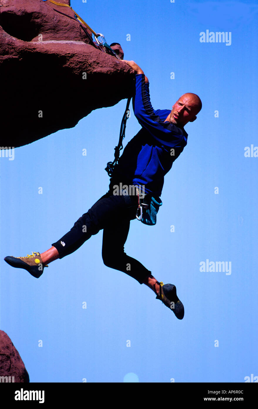 Rock climber hanging from cliff face in Fisher Towers, Colorado River ...