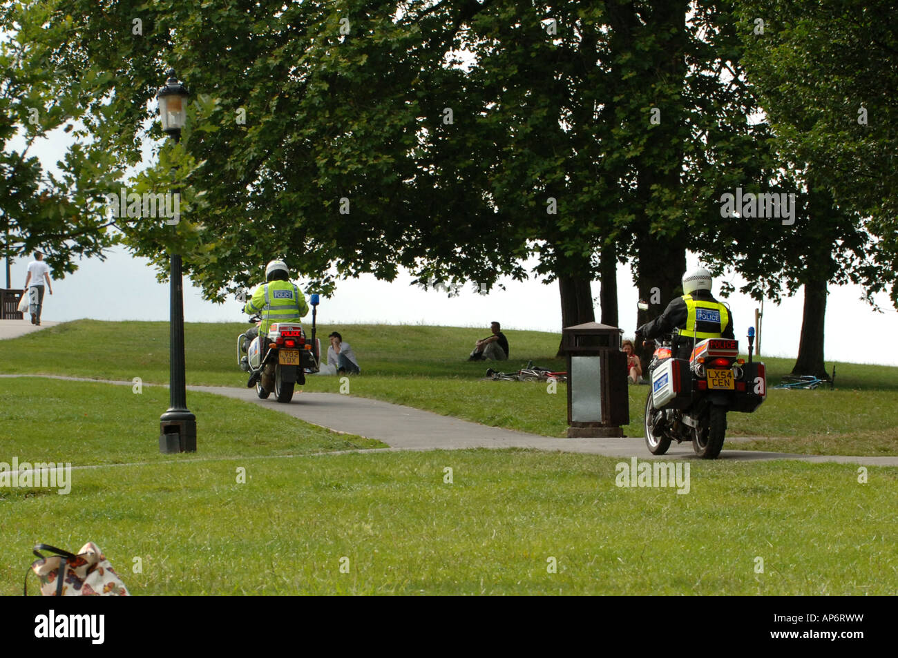 Police officers on motorbikes riding up the hill Primrose Hill park ...