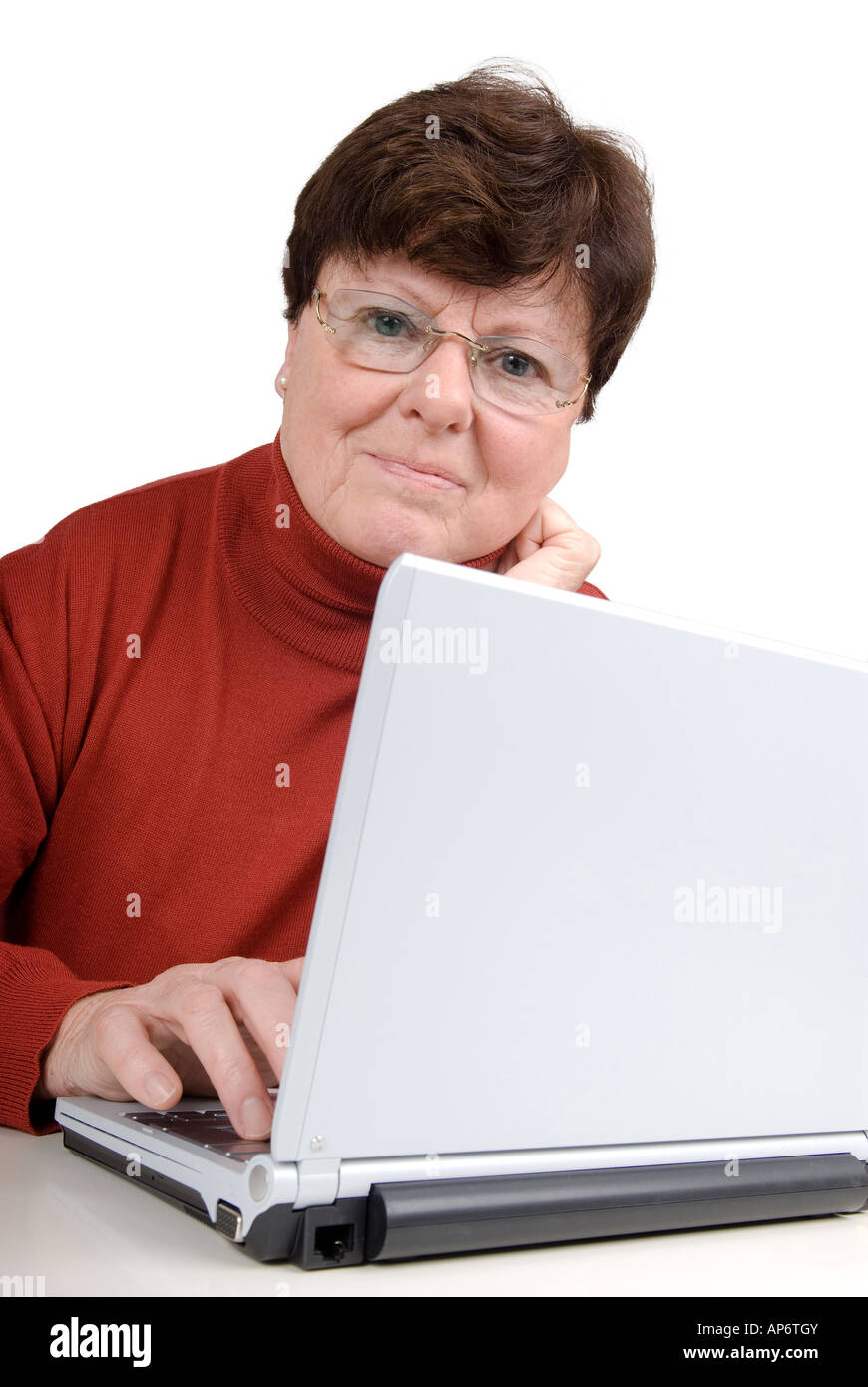 Senior woman in front of a computer. Studio picture. Full isolated ...
