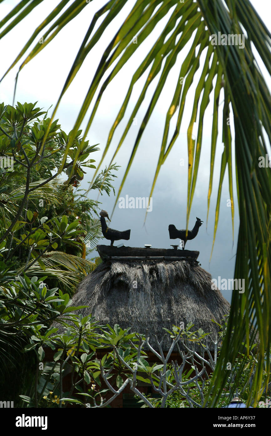 Thatched roof with sculptures in tropical garden in Bali Indonesia ...