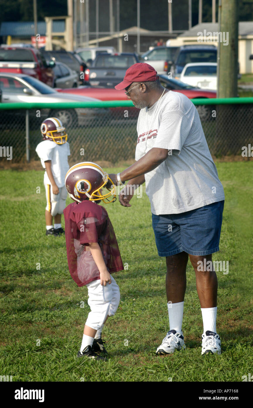 Coach with real young full contact football player in full uniform on ...