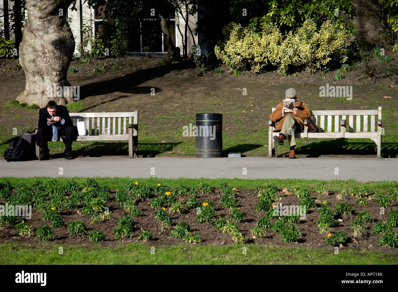 two men eat and read on benches seperately Stock Photo - Alamy