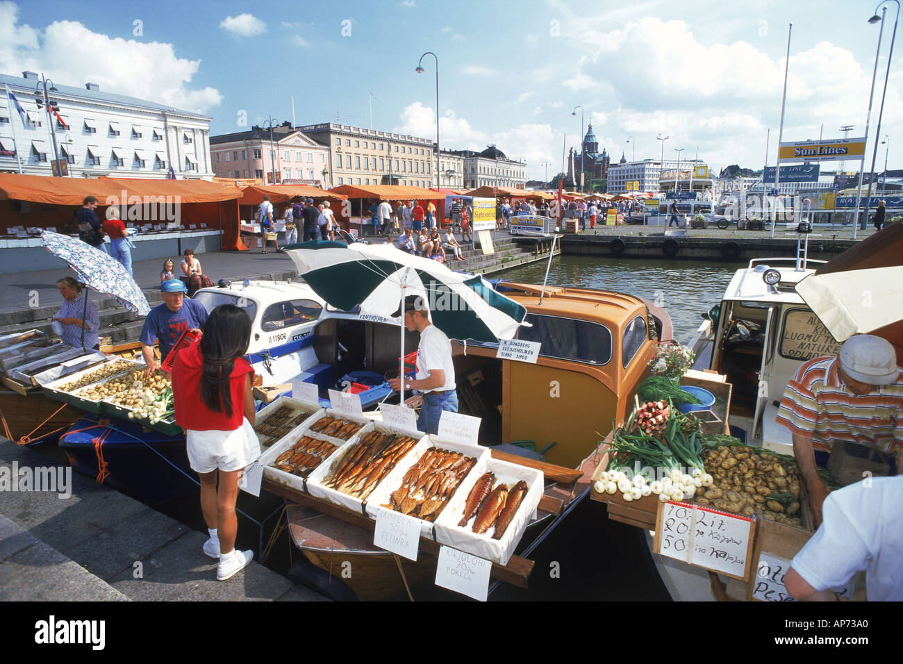 People buying and selling fresh fish off back of boats in market place ...