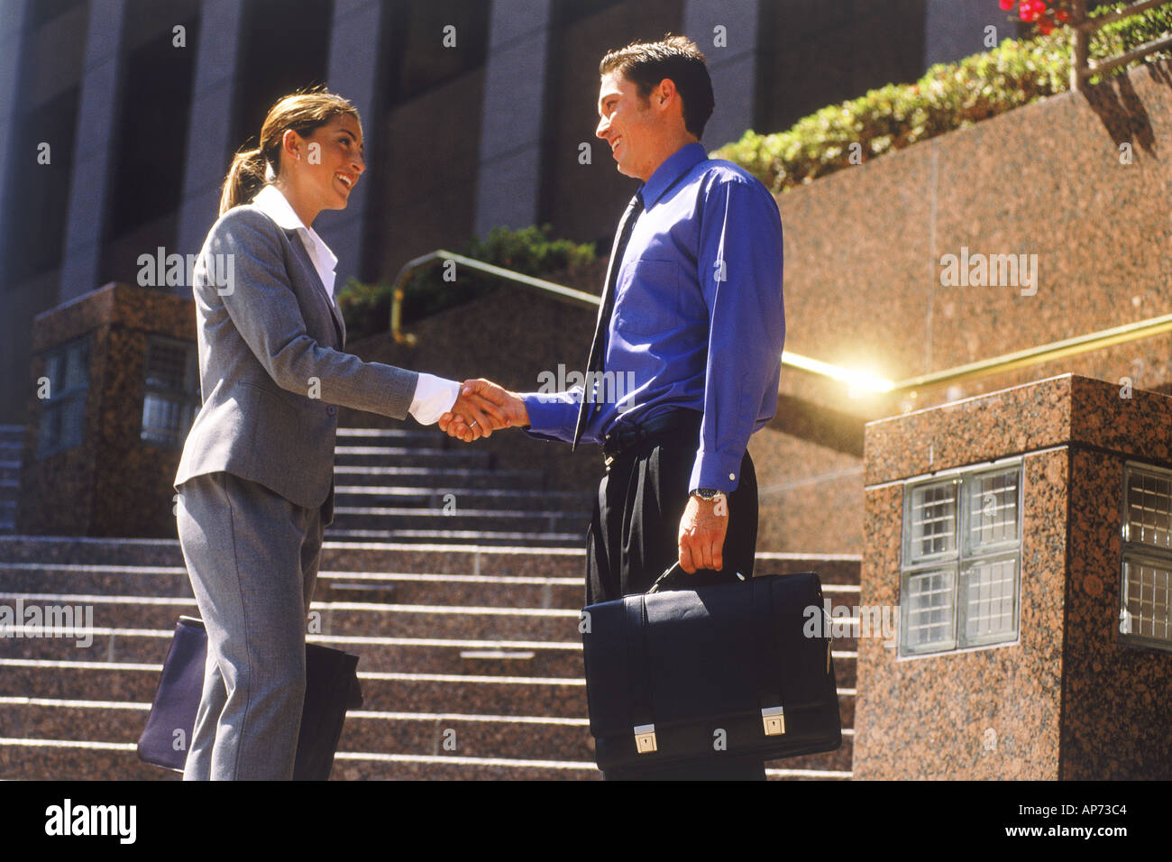 Businessman and woman shaking hands on steps in Los Angeles Stock Photo ...