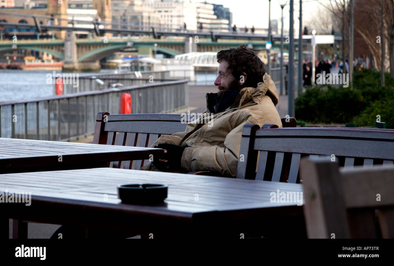 Homeless man smiling on a bench in London Stock Photo - Alamy