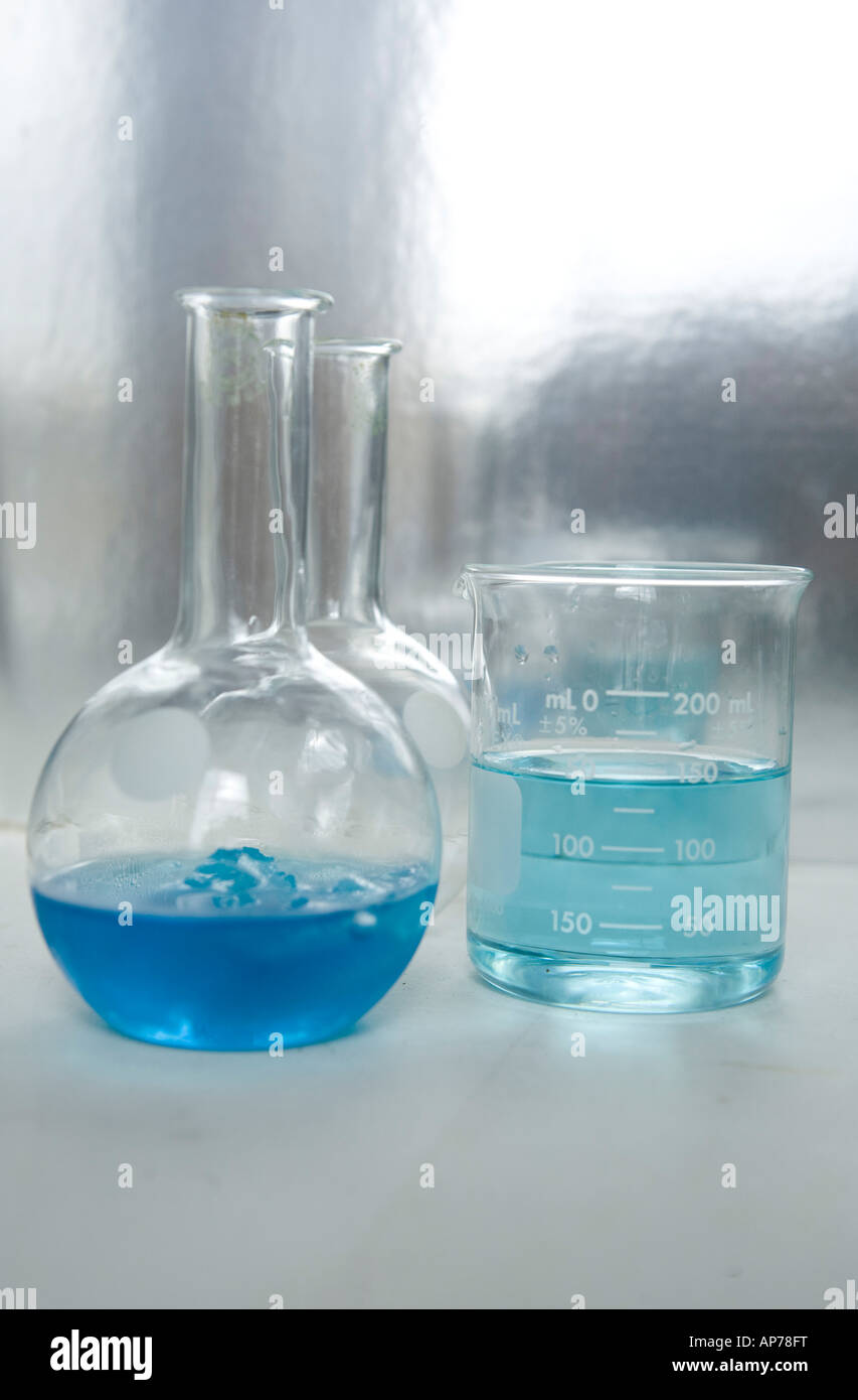 science research chemistry flasks and beakers with blue solution in ...