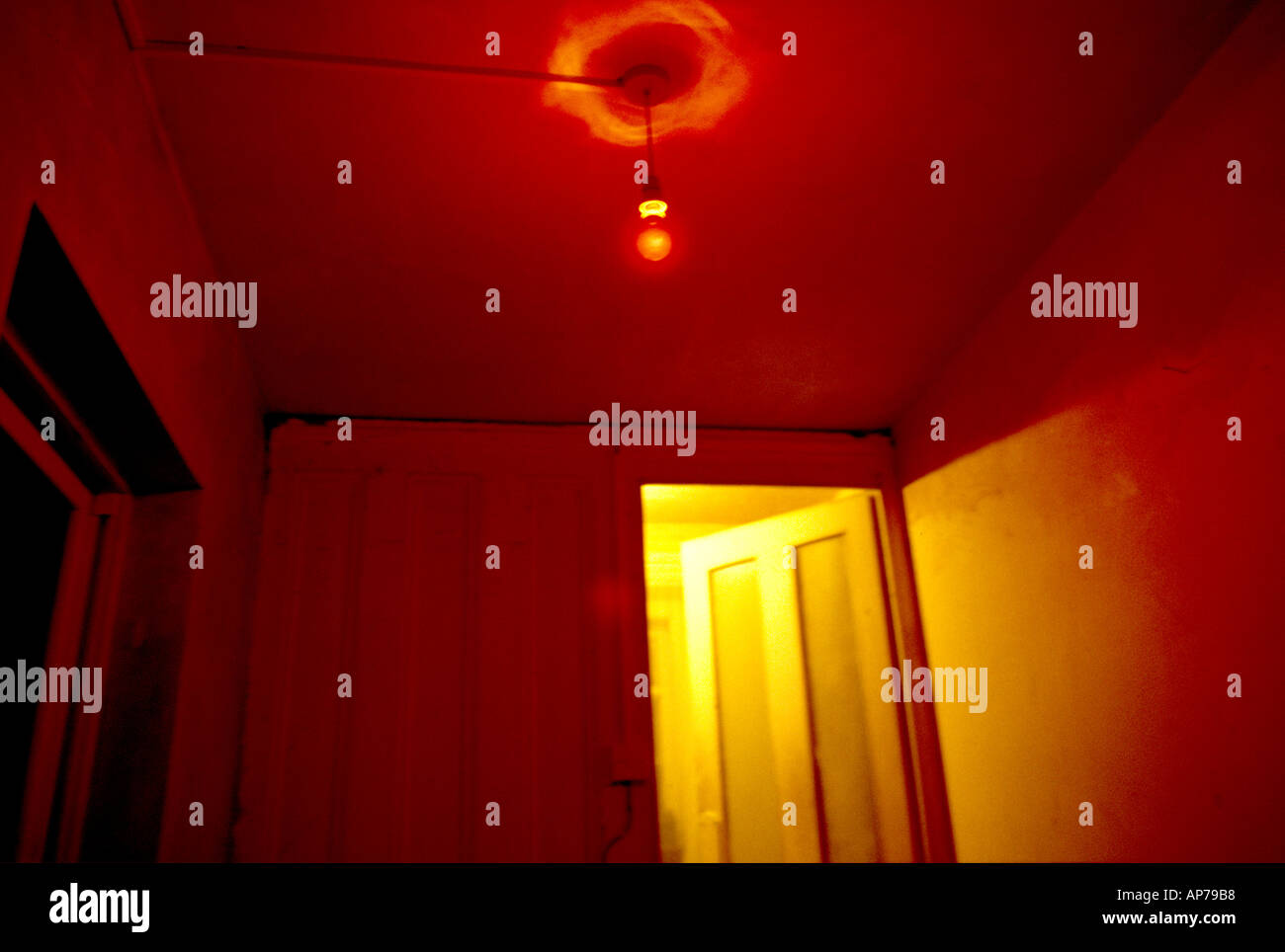 Red light in hallway with yellow doorway Stock Photo - Alamy
