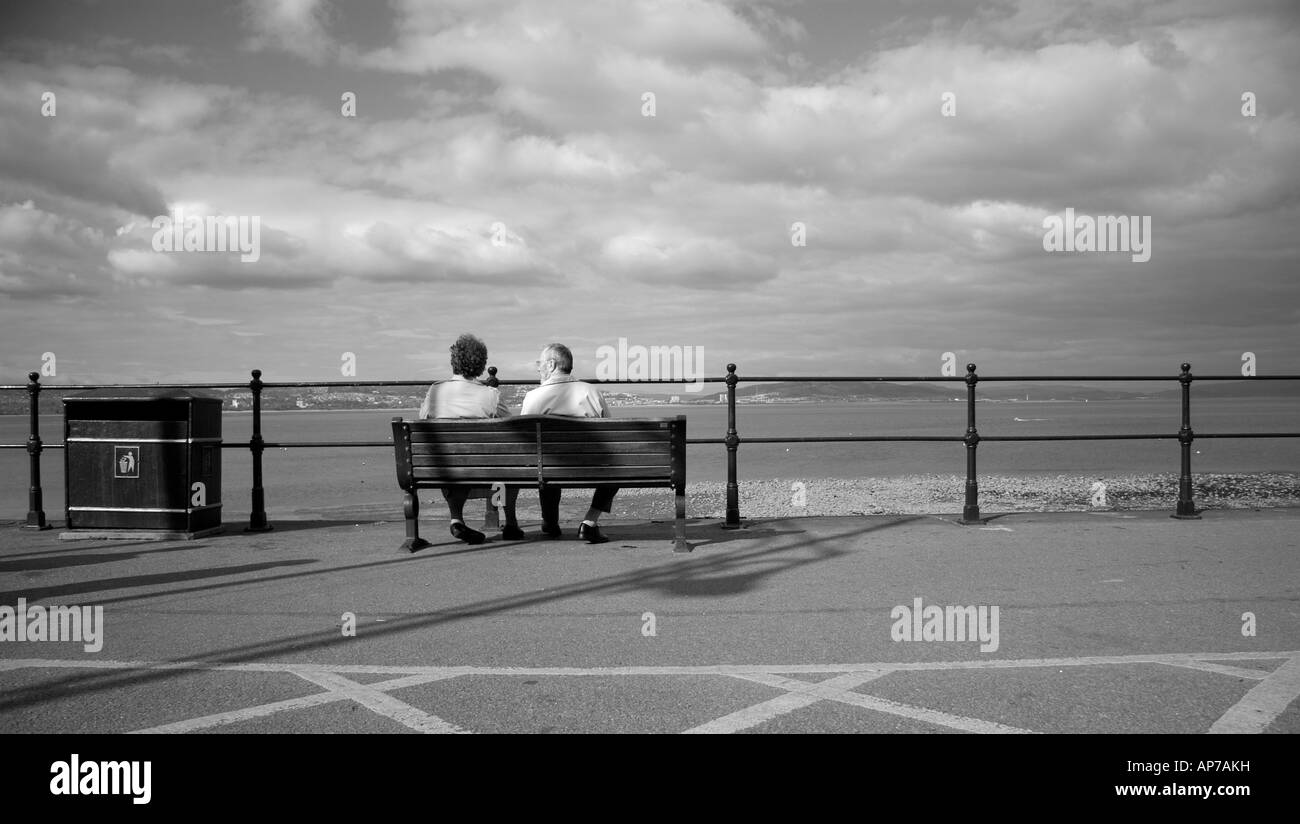 Man & a woman sitting on a bench on the promenade Stock Photo - Alamy