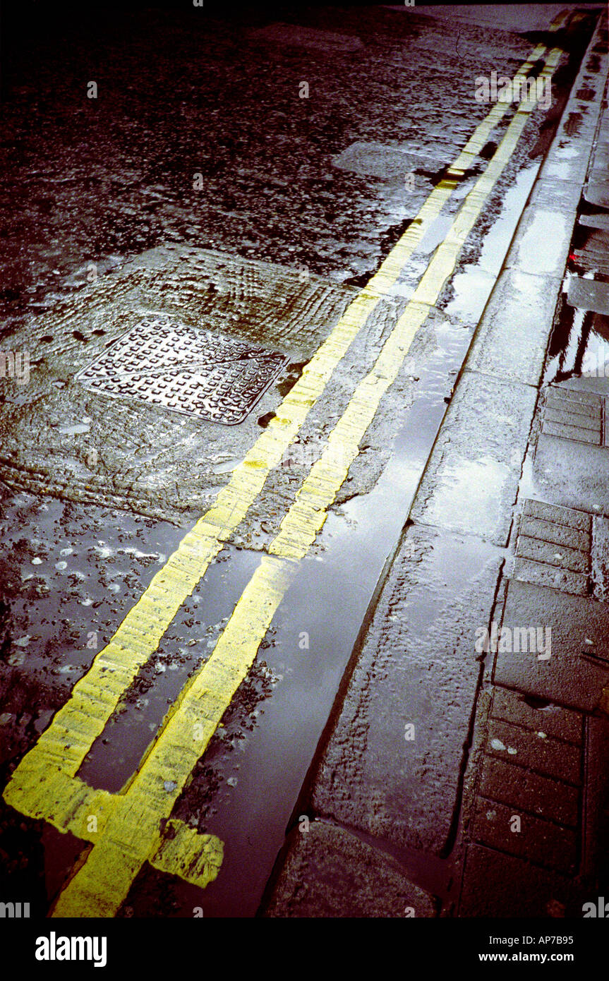Wet double yellow lines puddle Stock Photo - Alamy