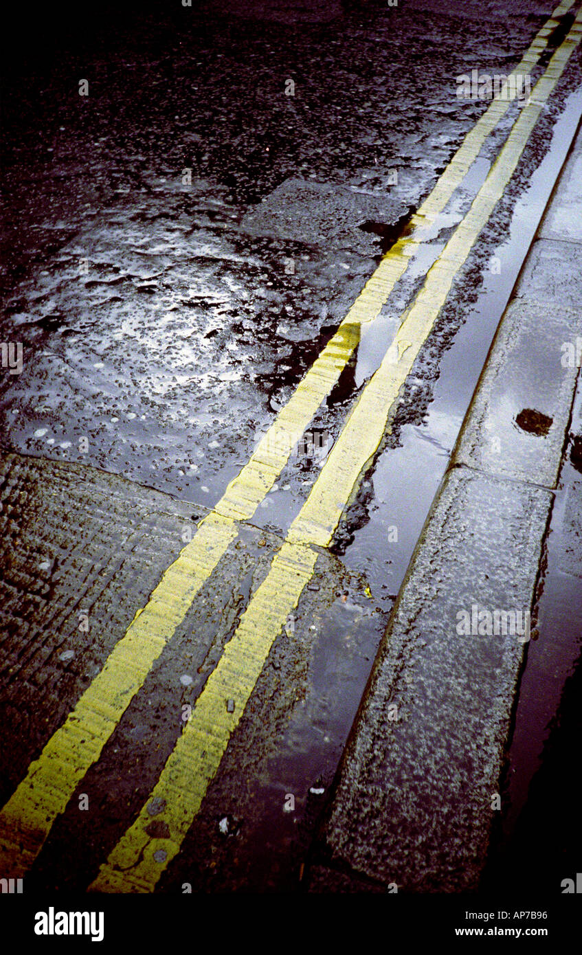 Wet double yellow lines puddle Stock Photo - Alamy