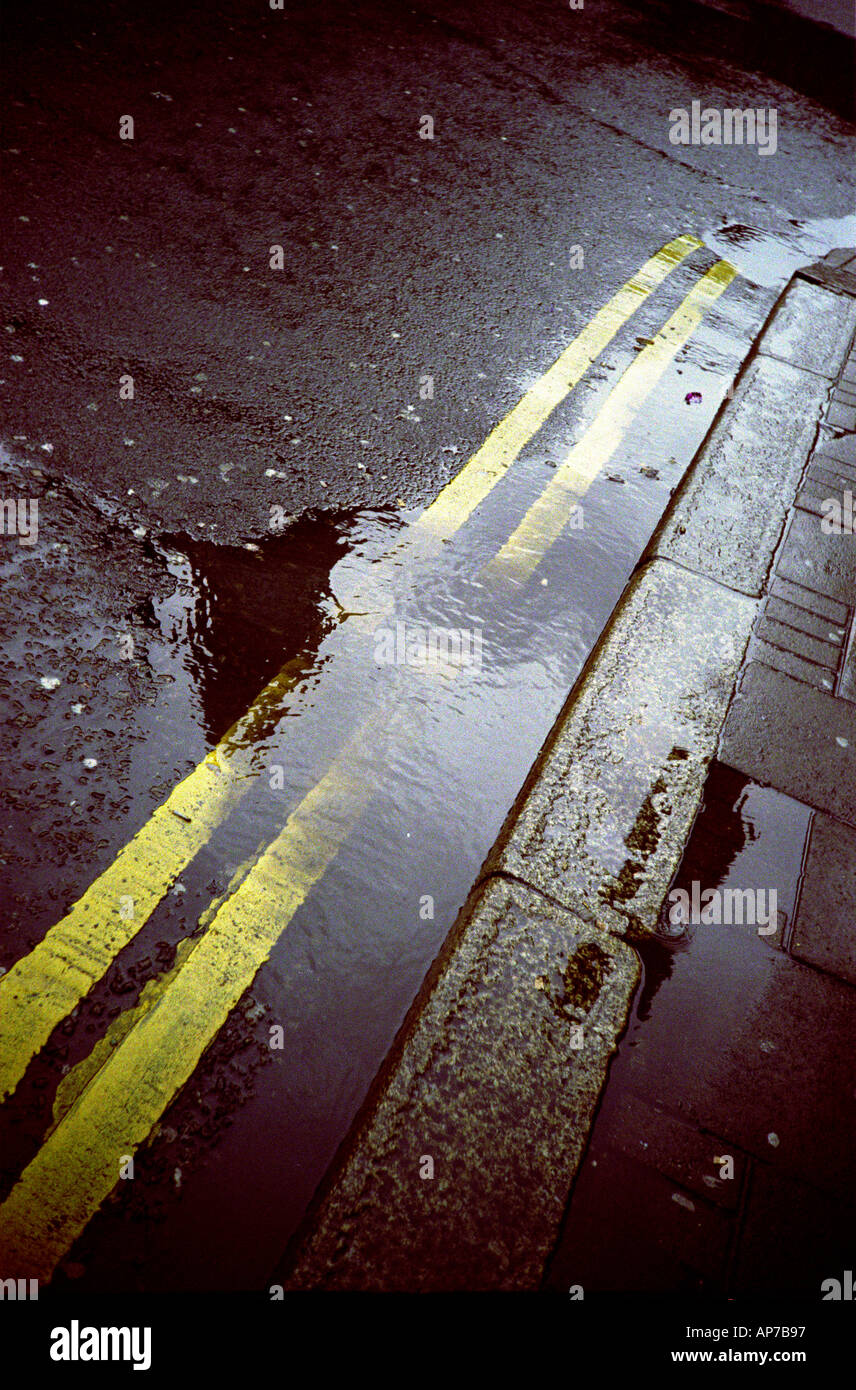 Wet double yellow lines puddle Stock Photo - Alamy