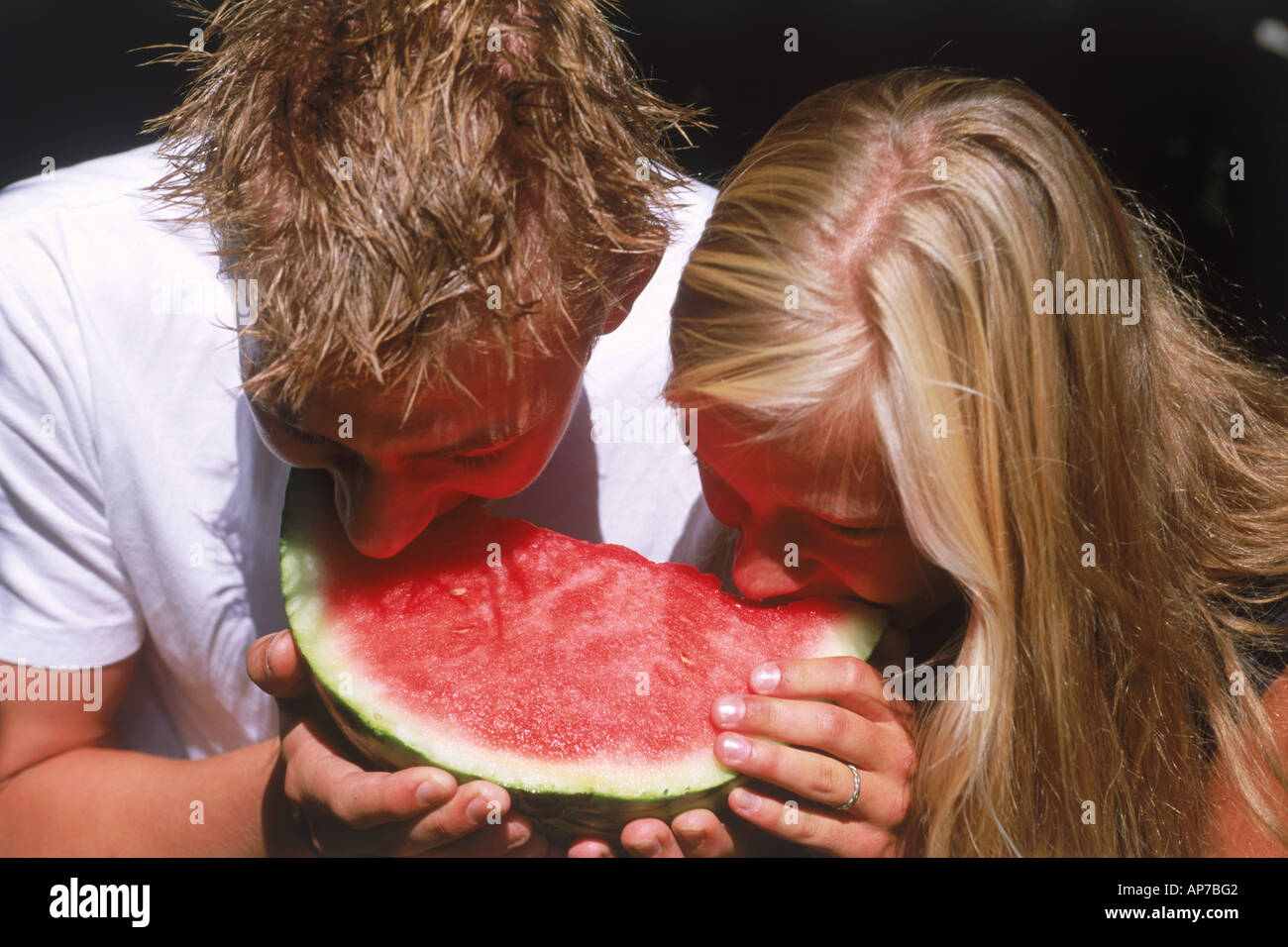 Young couple eating same slice of watermelon Stock Photo - Alamy