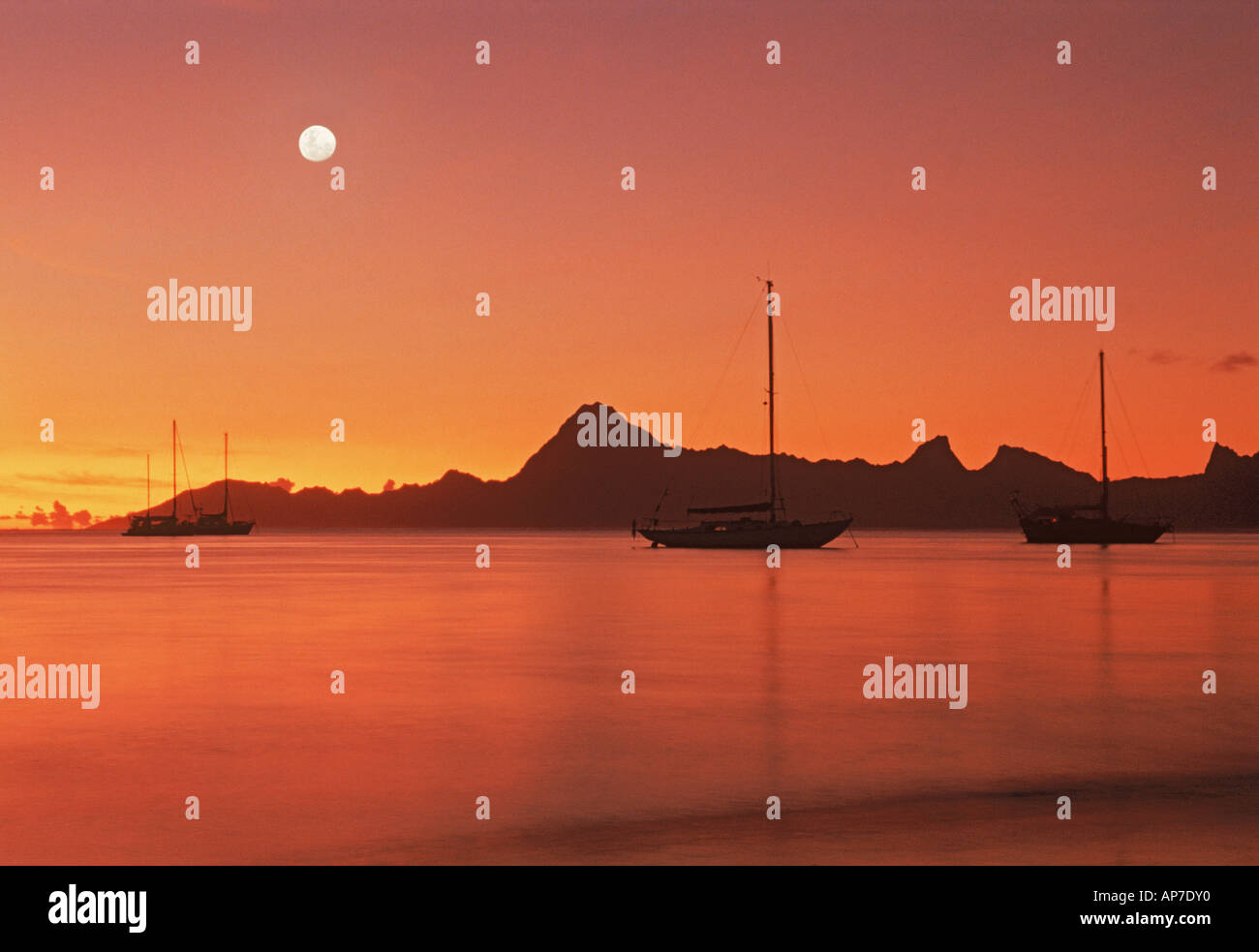 Full moon over distant Moorea from island of Tahiti with sailboats ...