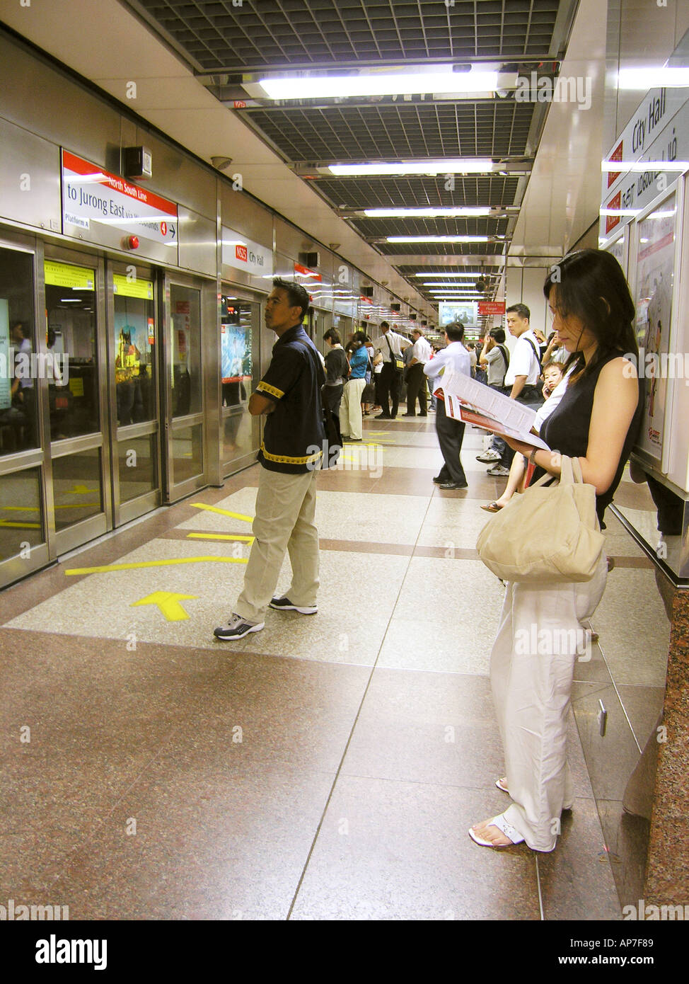Passengers waiting for train to arrive at City Hall MRT Station ...