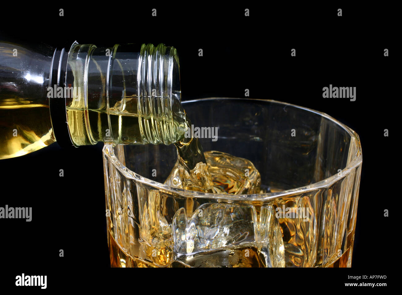 Pouring a glass of whisky or whiskey onto ice Stock Photo - Alamy