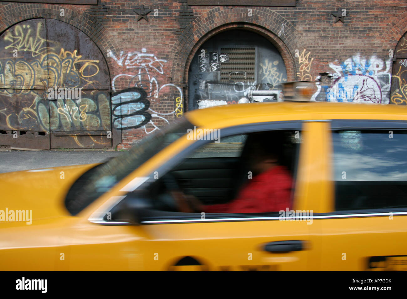 Yellow taxi cab passing wall of Graffiti in Brooklyn New York Stock ...