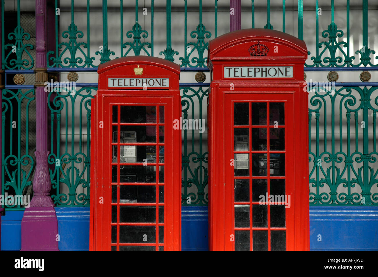 Two traditional British red telephone boxes against colourful Victorian ...