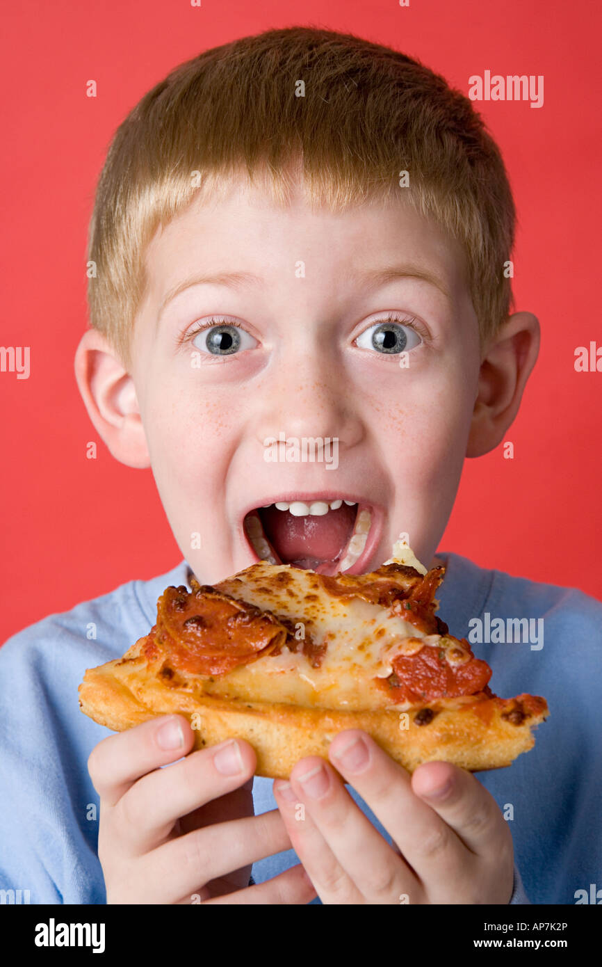 Boy eating pizza Stock Photo - Alamy