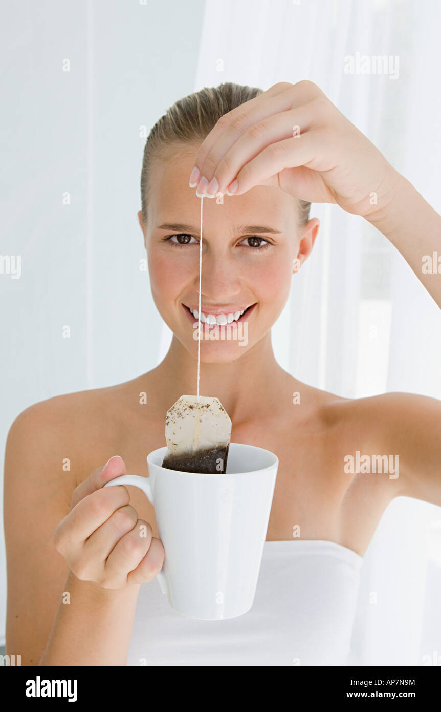 Young woman holding tea bag Stock Photo - Alamy