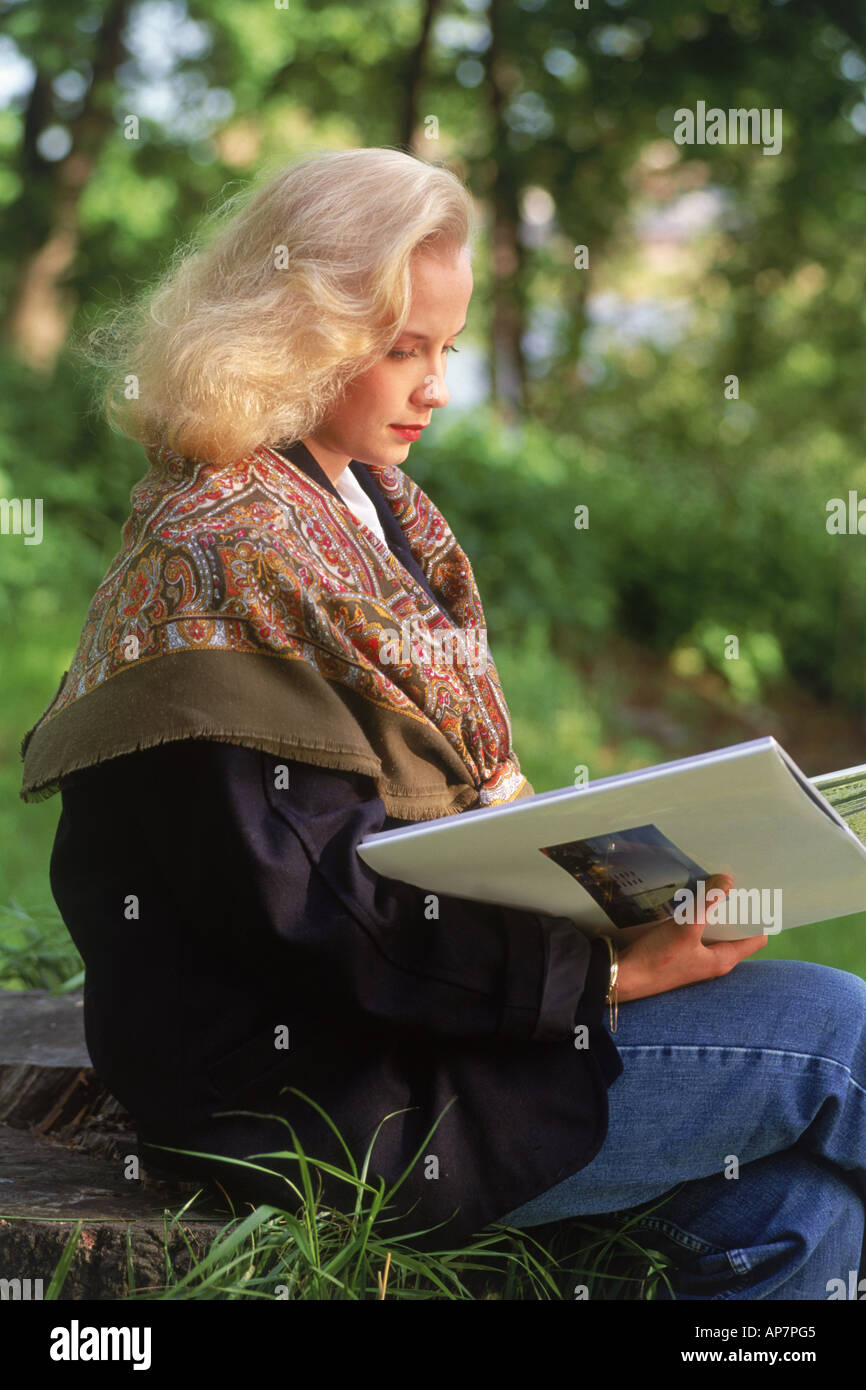 Finnish woman sitting outdoors reading a book Stock Photo - Alamy