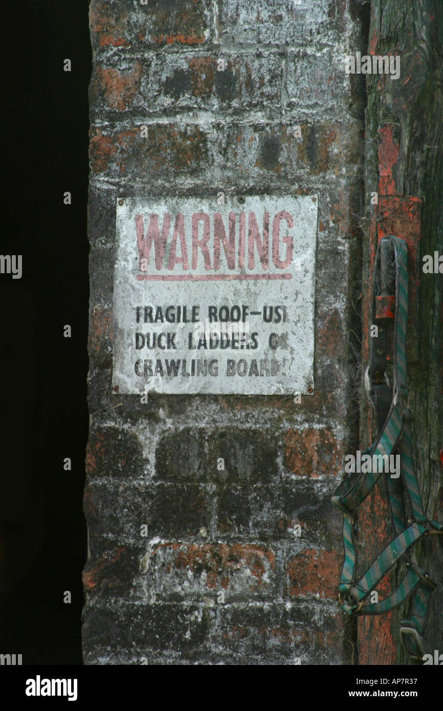 Old fragile roof warning sign on brick pillar Stock Photo - Alamy
