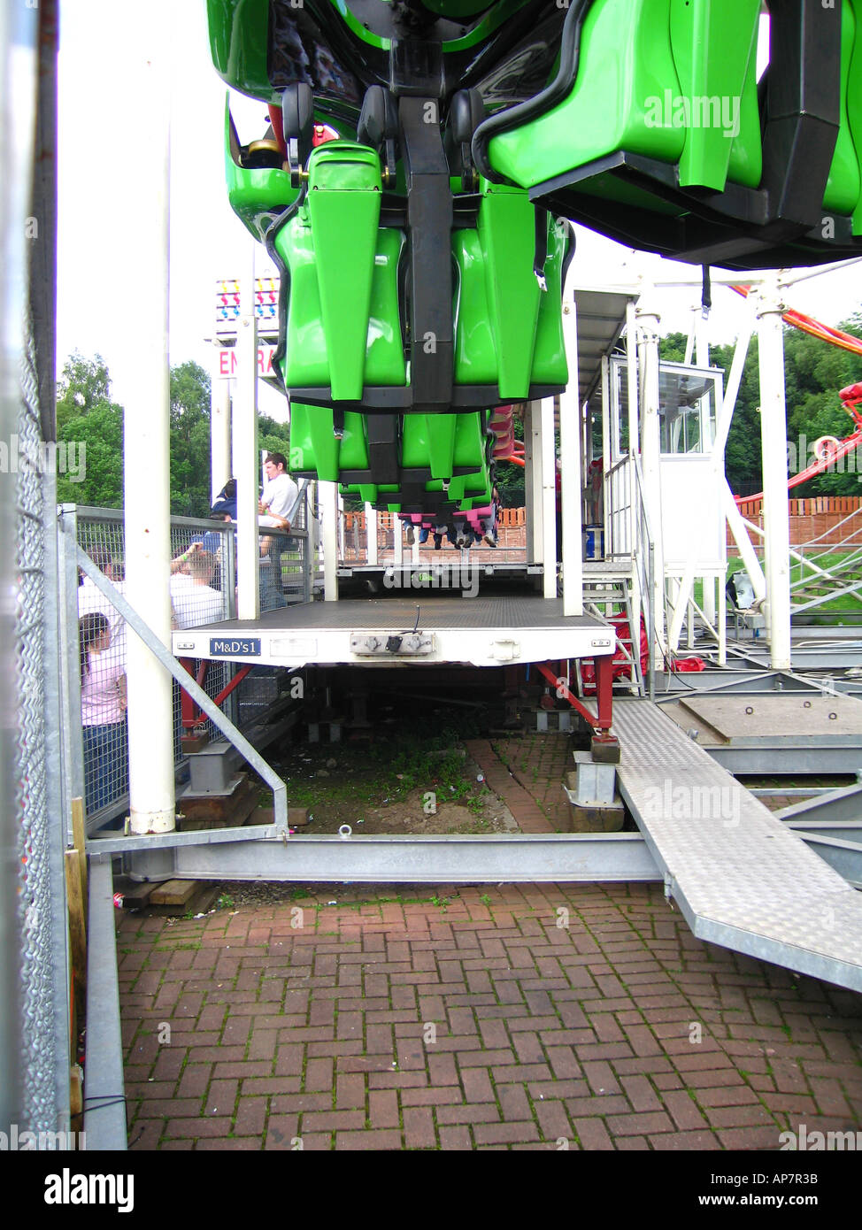 Seats with riders legs on hanging style roller coaster about to start ...