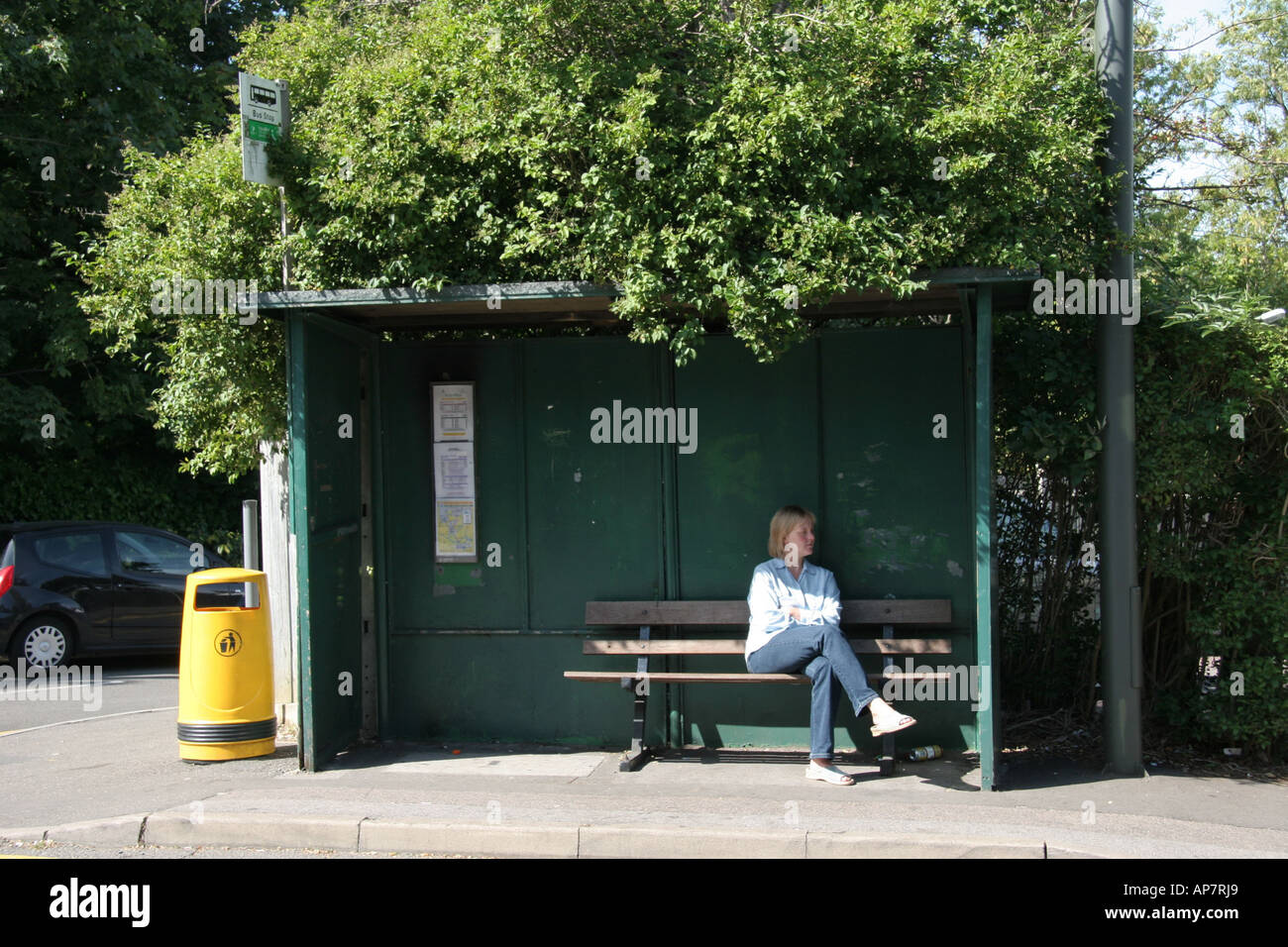 woman waiting at bus stop shelter Stock Photo - Alamy