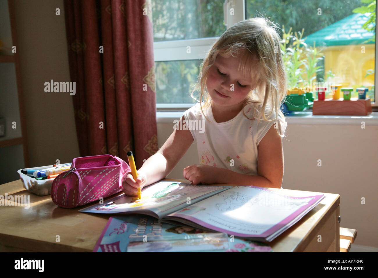 Young girl using colouring book Stock Photo - Alamy