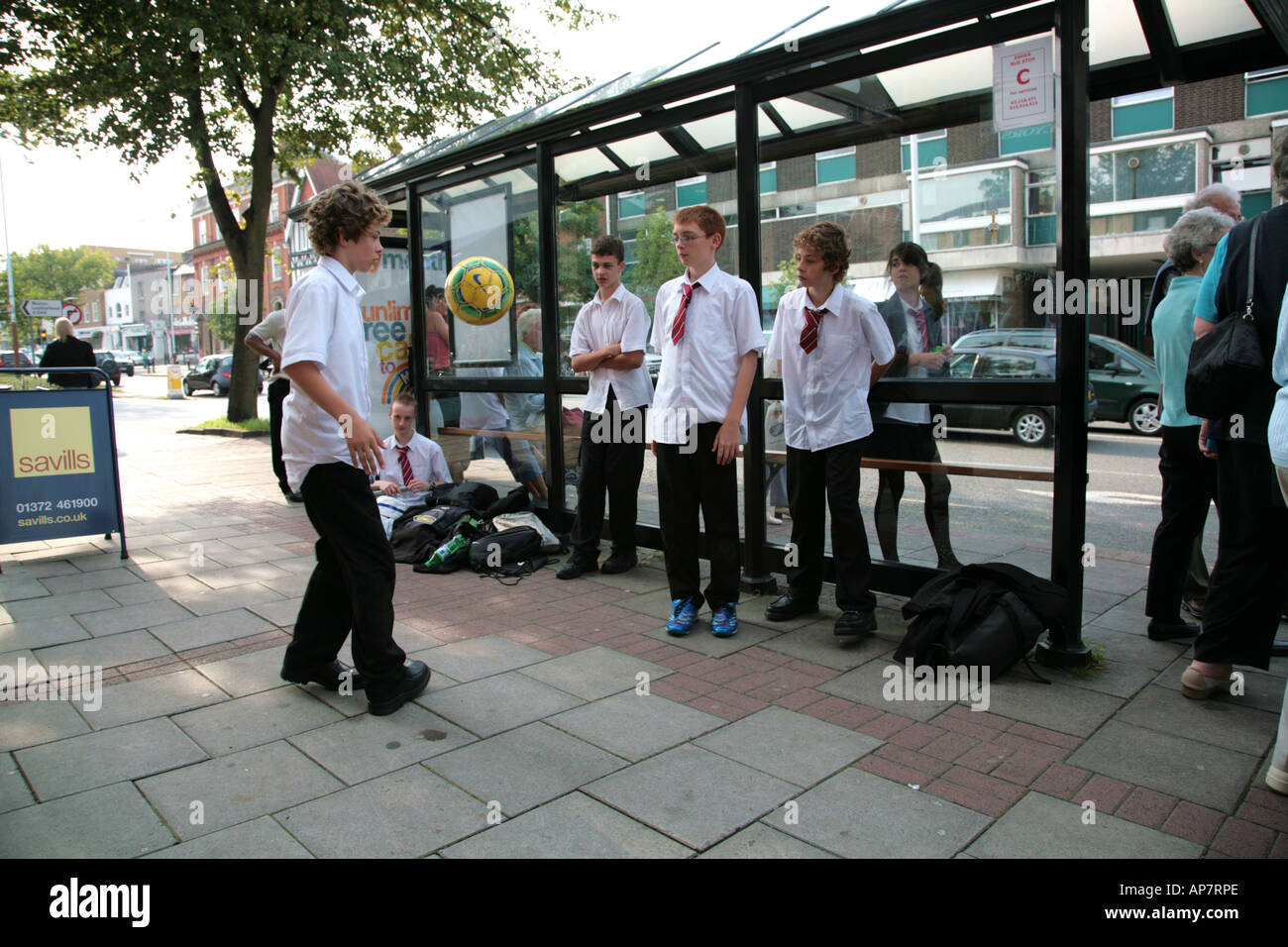 school boys playing football at bus stop Stock Photo - Alamy