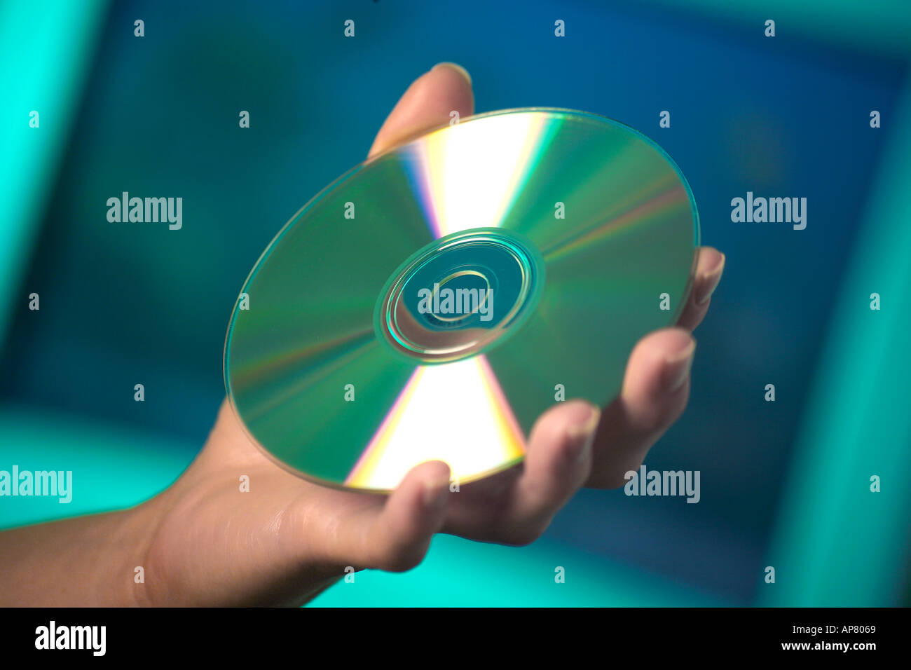 Hand holding cd infront of computer screen Stock Photo - Alamy