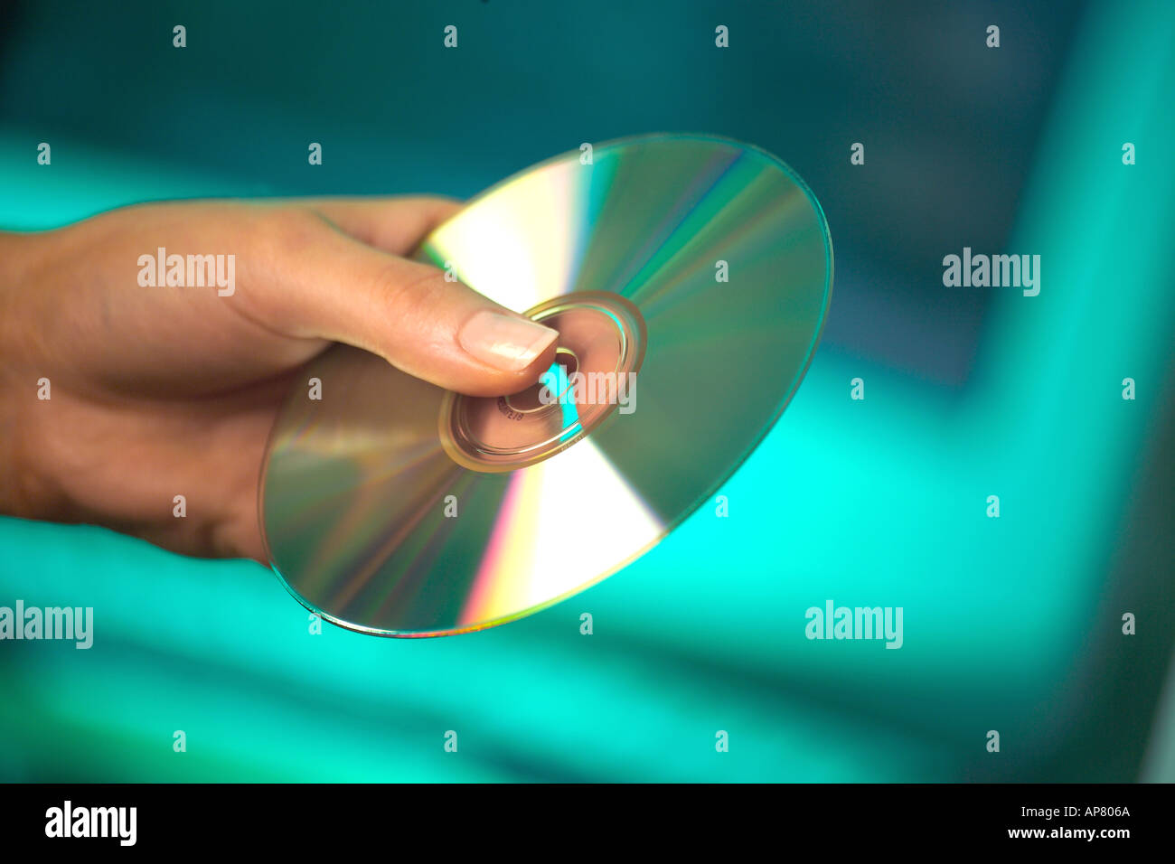 Hand holding cd infront of computer screen Stock Photo - Alamy