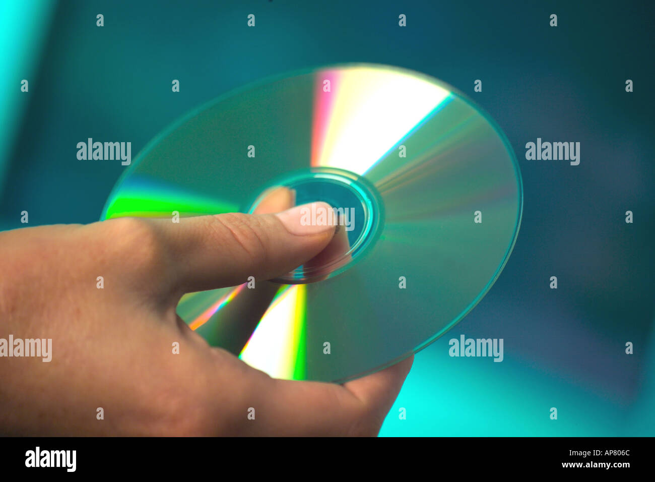 Hand holding cd infront of computer screen Stock Photo - Alamy